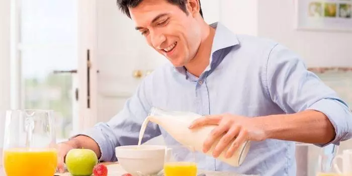 Lelaki makan sarapan di dapur