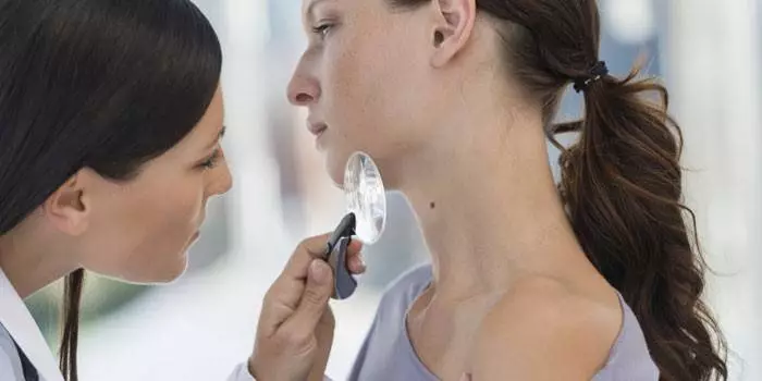 Dermatolog zkoumá kůži dívky