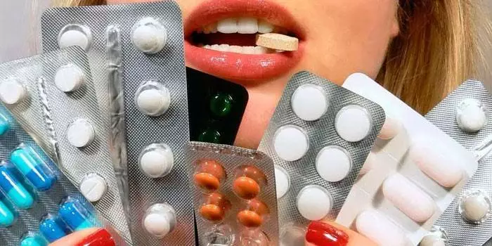 Pilulky a kapsle v rukou dívky