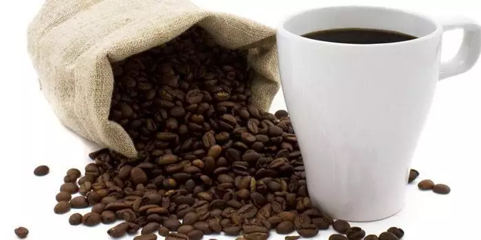 Boabe de cafea și o ceașcă cu o băutură