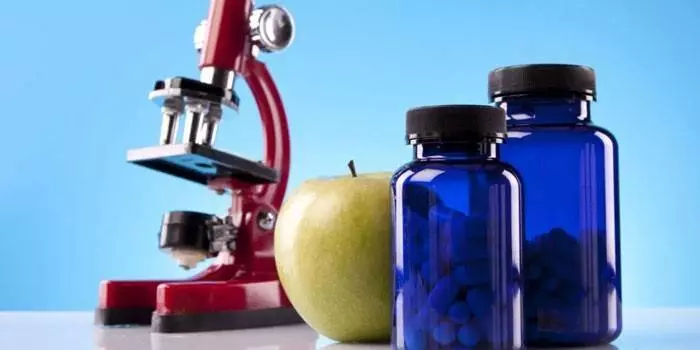 Микроскоп, ябълка и хапчета