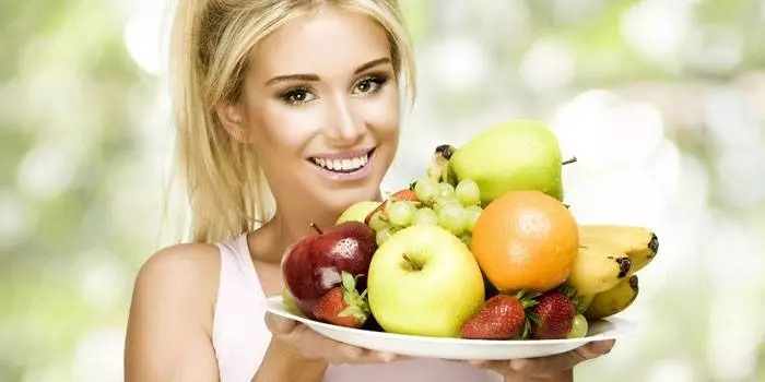 Rapaza sostendo un prato de froita