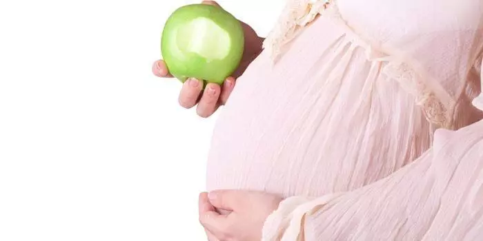 Cô gái mang thai với quả táo trong tay