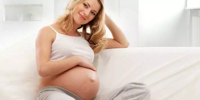 Kanepede oturan hamile kız