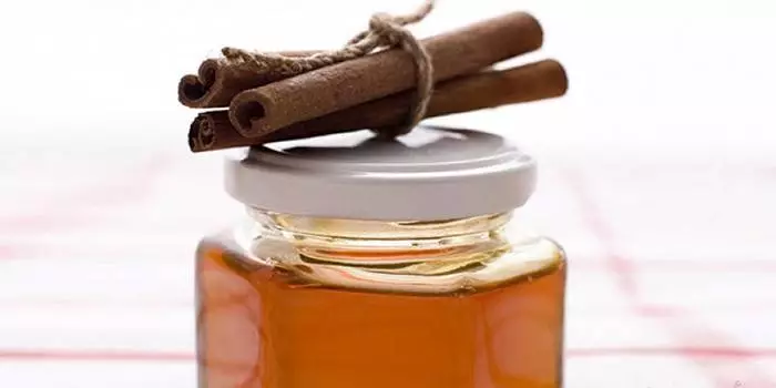 Bastonets de canyella i un pot de mel