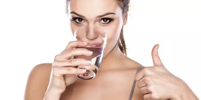 หญิงสาวดื่มน้ำจากแก้ว