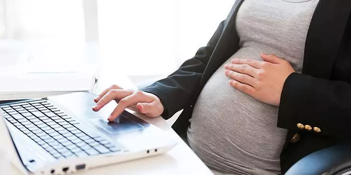 Schwangere frou op laptop