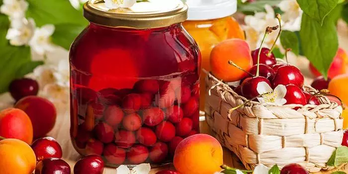 Jars of cherry and apricot compote and fruits