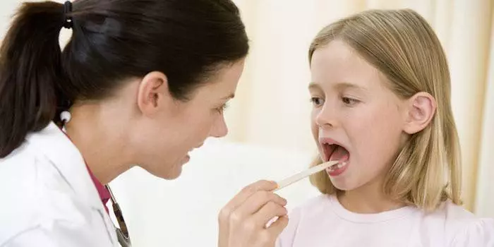 O médico examina a garganta da criança