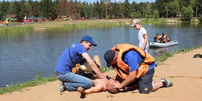 Az ember elsősegélyt kap a strandon