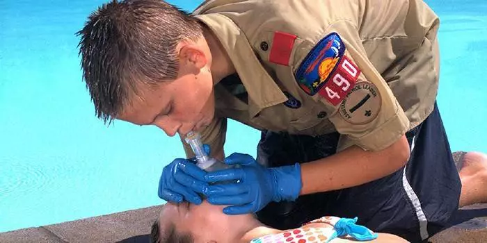 Lifeguard memberi pernafasan buatan seorang gadis di tepi kolam renang