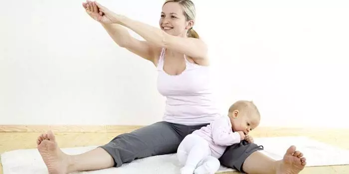 Jeune maman faisant des exercices avec son bébé