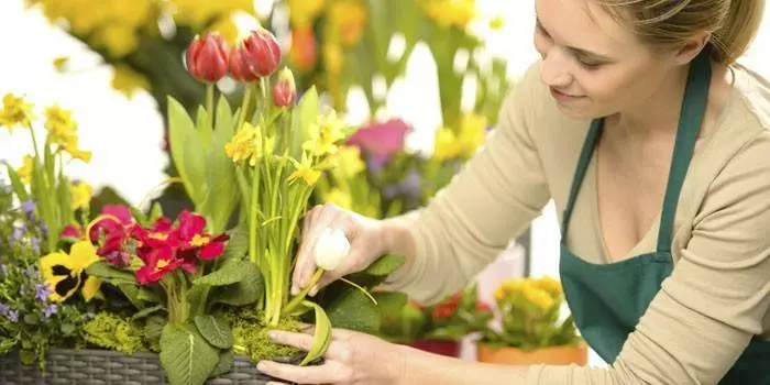 Blomsterhandlerpiken lager en bukett