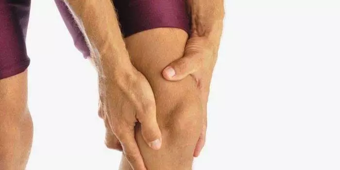 A man holding his knee with his hands