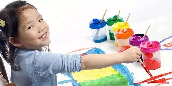 Момиче рисува с бои
