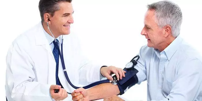 Lääkäri mittaa miehen painetta potilaaseen
