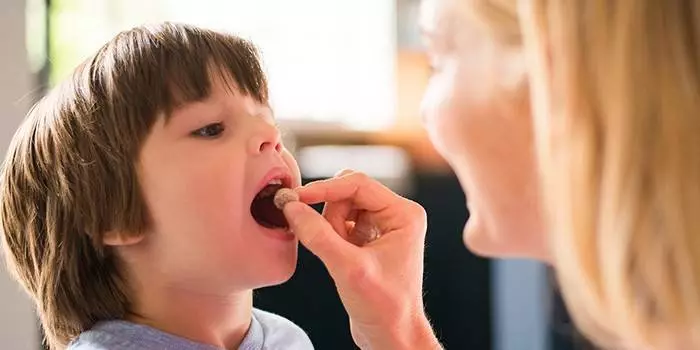 Mom gives the baby a pill