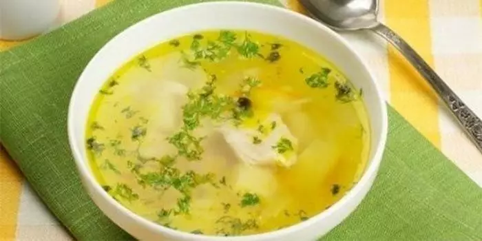 Chicken breast broth with herbs in a plate