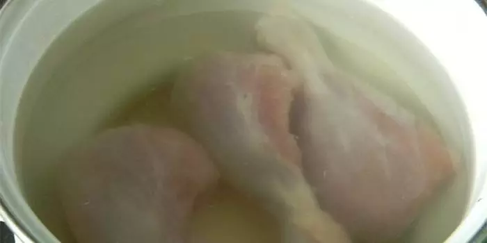 Chicken drumsticks in a pot of water