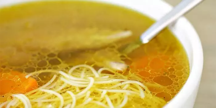 Rich chicken broth with noodles in a plate