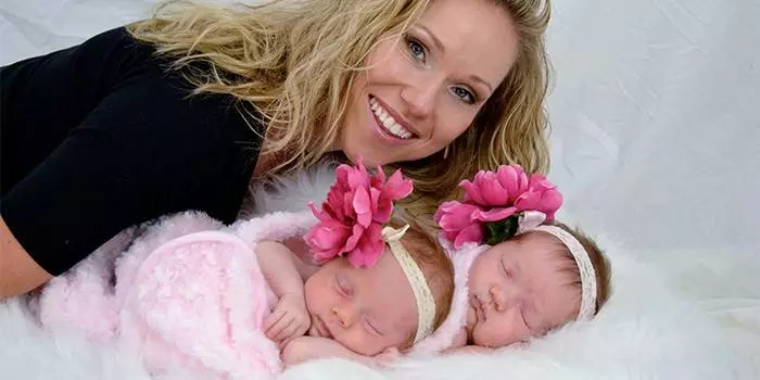 Frau mit neugeborenen Zwillingsmädchen