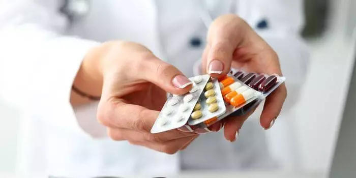 Tabletas y cápsulas en manos de un médico.