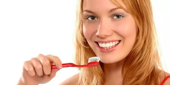 หญิงสาวที่มีแปรงสีฟันอยู่ในมือ