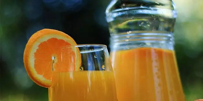 Kanne og et glass appelsinjuice