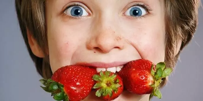 Băiat cu căpșuni în gură