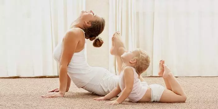 Nanay at sanggol ay nag-yoga sa bahay