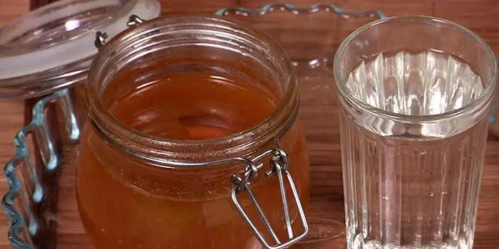 Un bote de mel e un vaso de auga