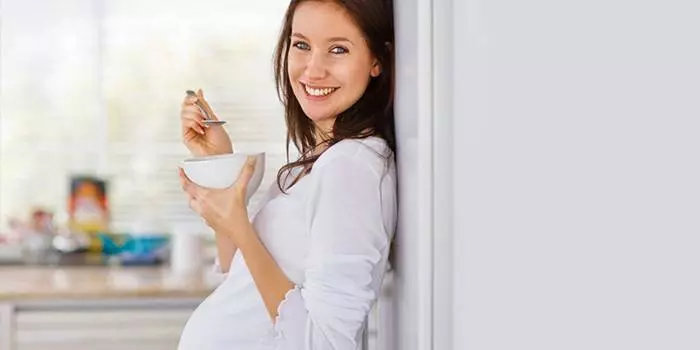 Pregnant girl eating breakfast