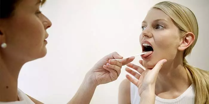 Bác sĩ kiểm tra cổ họng của cô gái