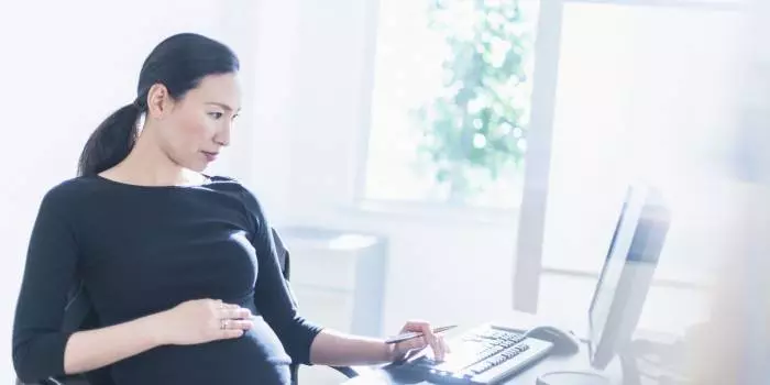 Бременна жена на компютъра