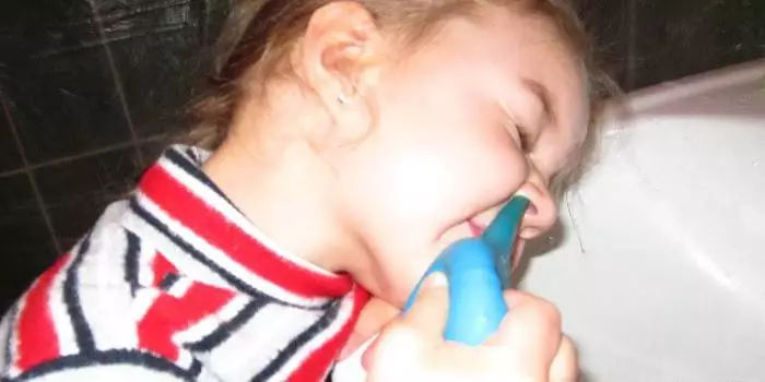 女の子が注射器で鼻を洗う