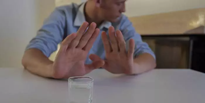 A man refuses a glass of vodka