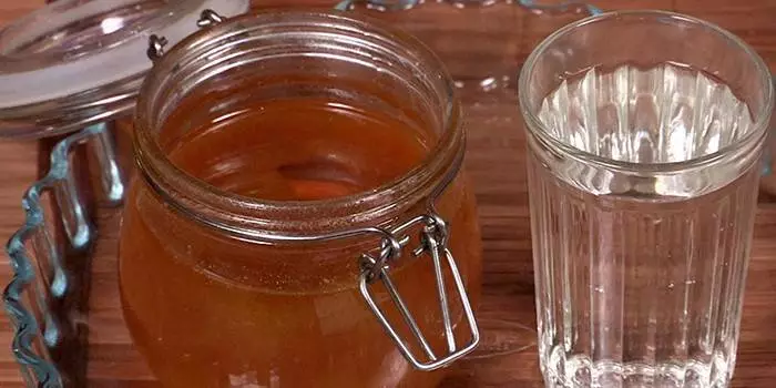 Um pote de mel e um copo de água