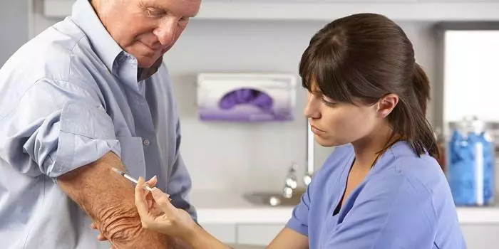 De medic geeft een injectie in de onderarm