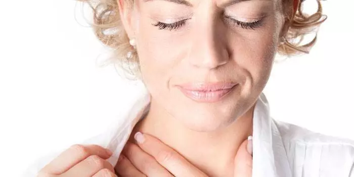 Mujer sosteniendo su garganta con su mano