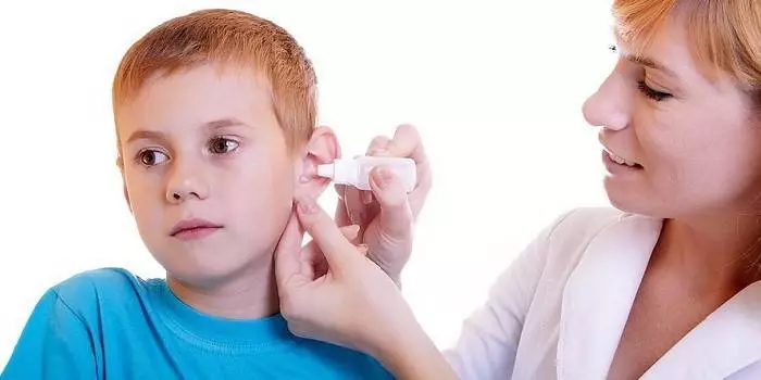 Der Arzt vergräbt das Ohr des Jungen