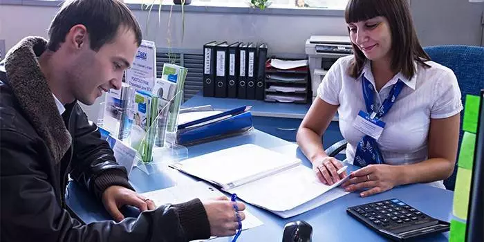 L'homme signe des documents à la banque