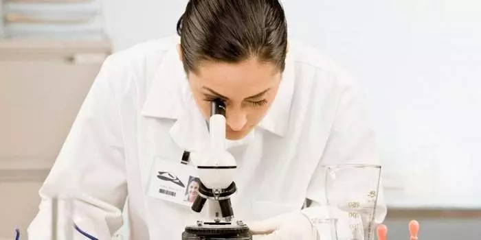 Laboratory assistant behind a microscope