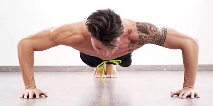A man performs a wide grip push-up