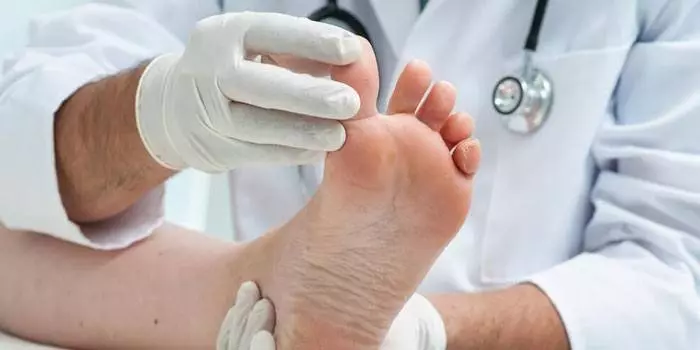 Ārsts pārbauda pacienta kāju
