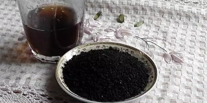 A cup of infusion and a plate of black cumin seeds