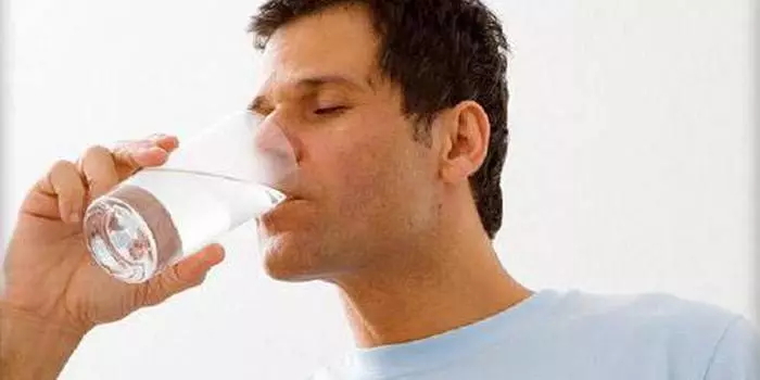 Lelaki minum air dari gelas