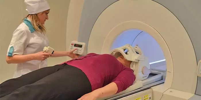Bilgisayarlı tomografi makinesinde bir kadın ve yakınlarda bir doktor.