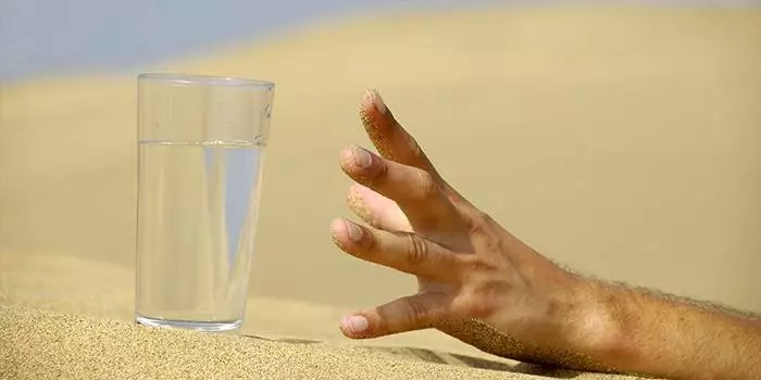 Hand reaches for a glass of water