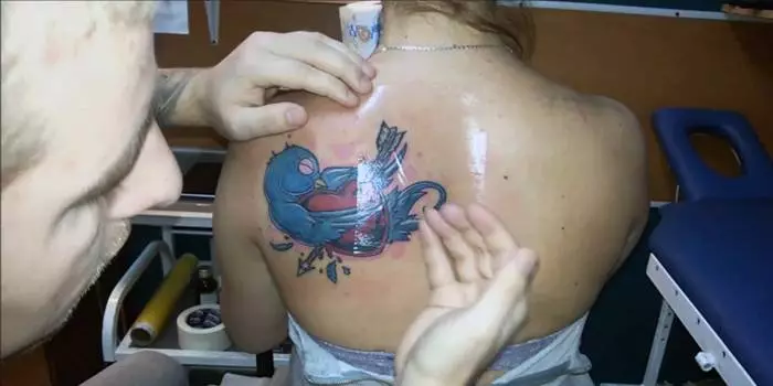 El artista pone una película sobre el tatuaje.