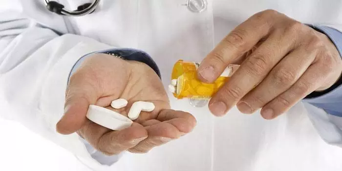 Hvite piller i håndflaten til en lege